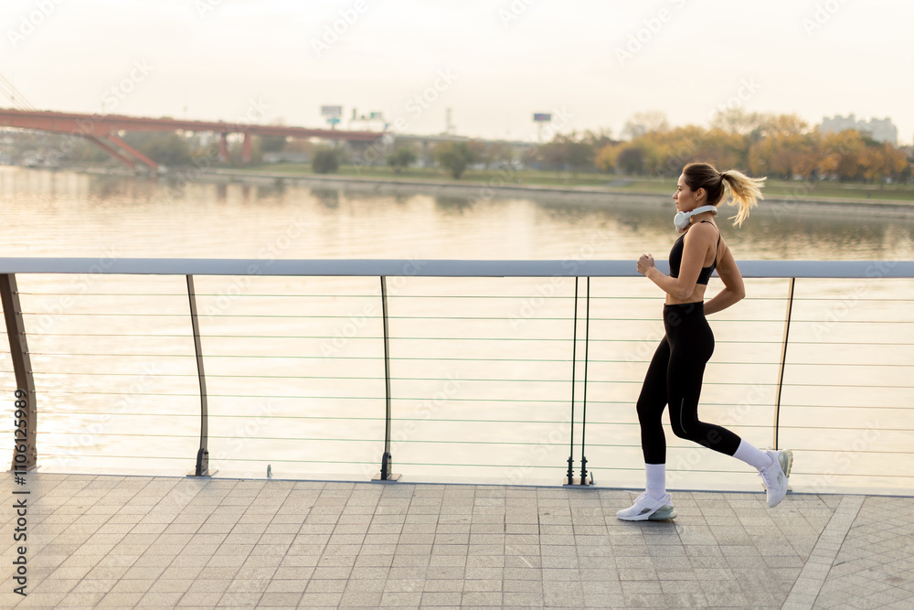 Early morning jogger enjoys a brisk run along a scenic waterfront ...