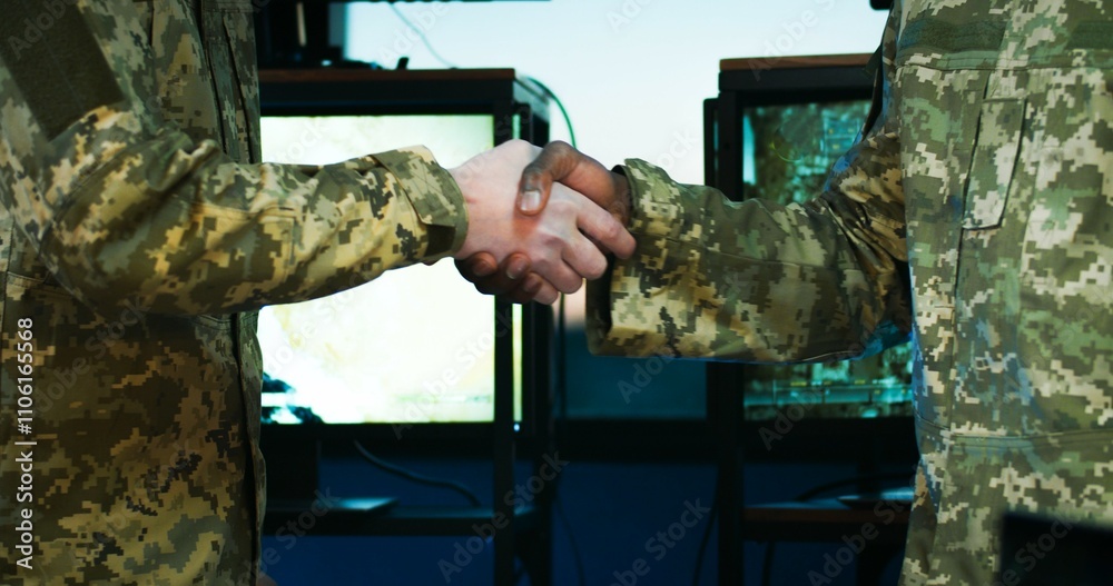 Mixed-races two militarian men in uniforms shaking hands as making deal ...