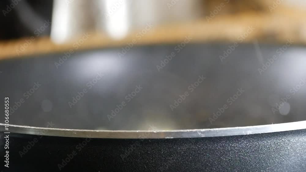 Steam rises from a pan on the kitchen countertop, filling the air with ...