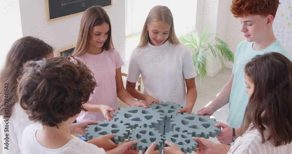 Group of high school children holding plastic gear wheels in their ...