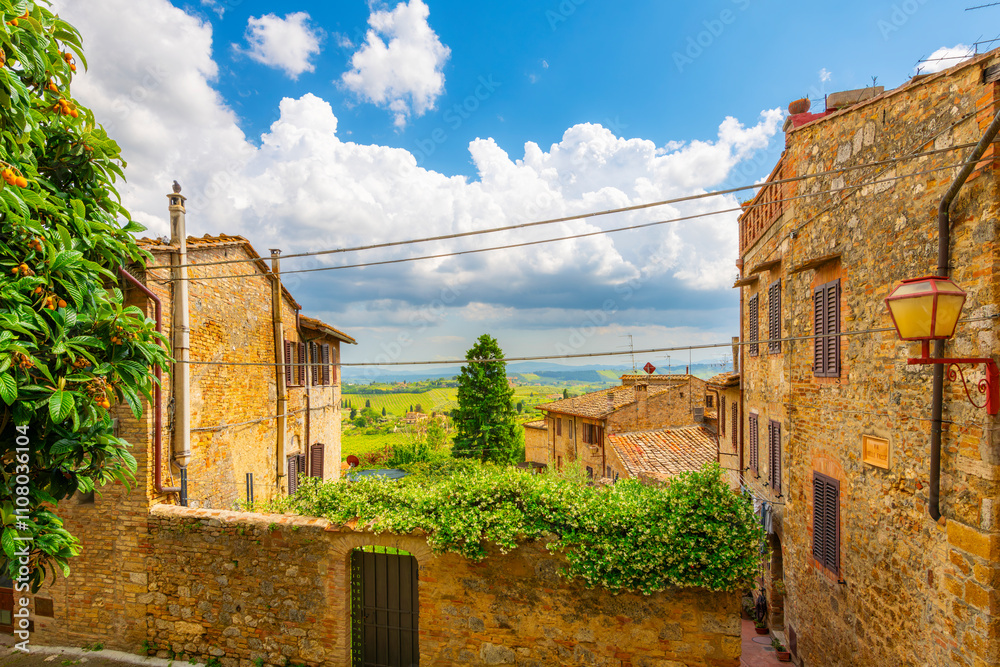 View of the Tuscan countryside from a garden between two medieval stone ...