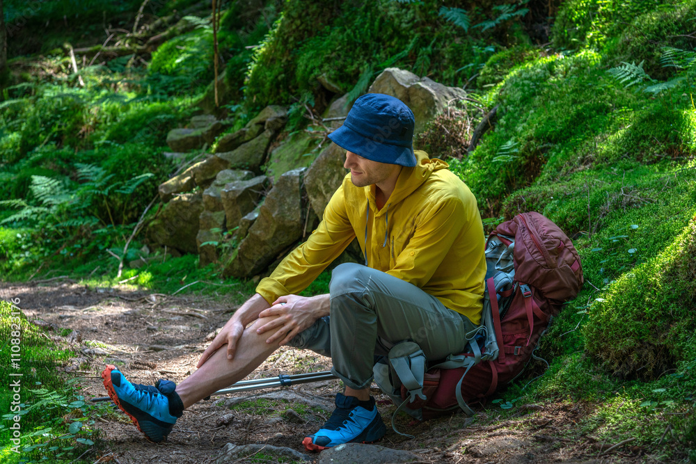 Knee injury on hiking outdoors in forest. Man holding knee by hands and ...