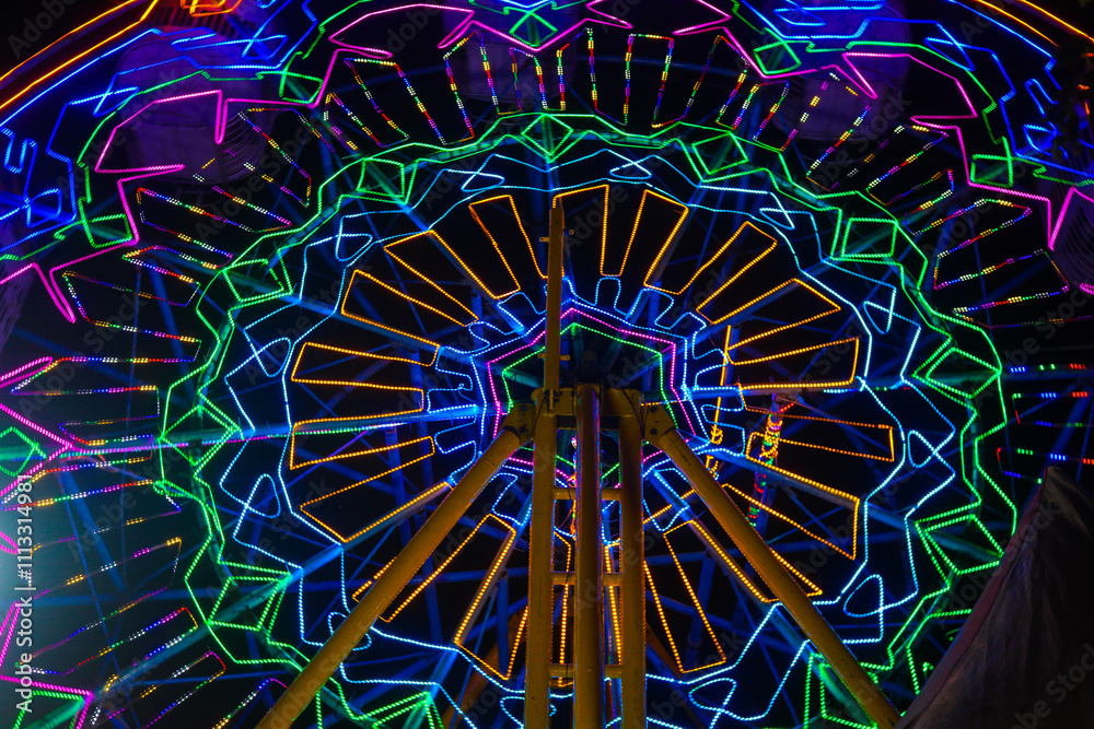 Ferris wheel up-close colorful light in the dark of the night time ...