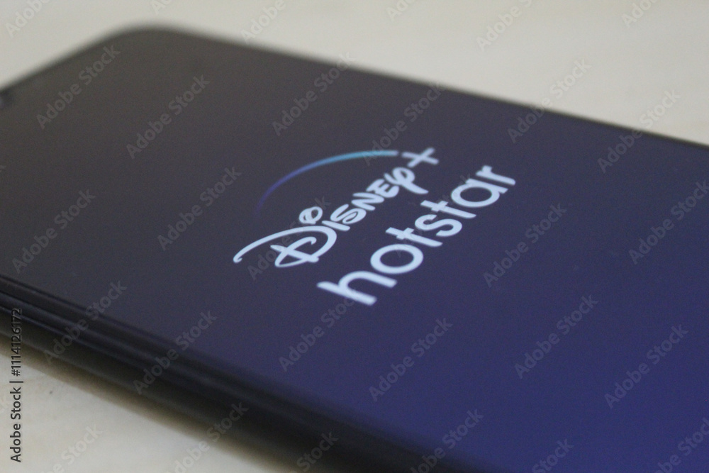 Disney+ Hotstar app logo display on a smartphone, black background hold ...