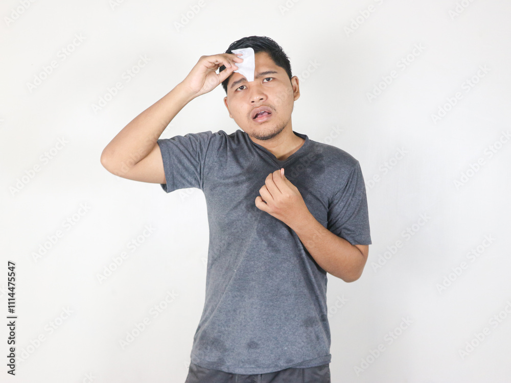 Asian man sweating while wiping sweat from his forehead with a tissue ...