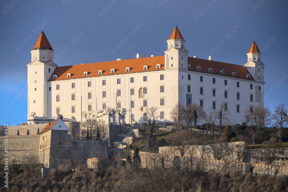 Bratislava Castle illuminated by soft sunlight, perched on a hill with ...