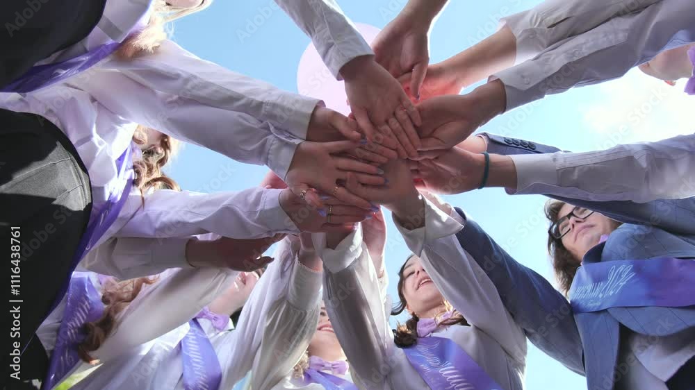 Graduating students gather in a circle, holding hands, commemorating ...