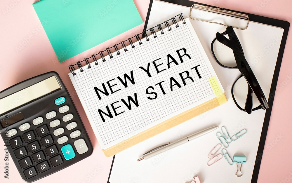 Notepad with NEW YEAR NEW START text on the office table with glasses ...