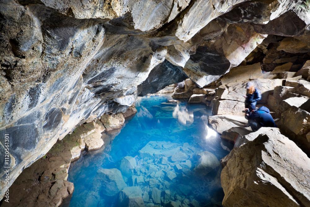 Unrecognizable tourists at Grjótagjá - small lava cave located near ...
