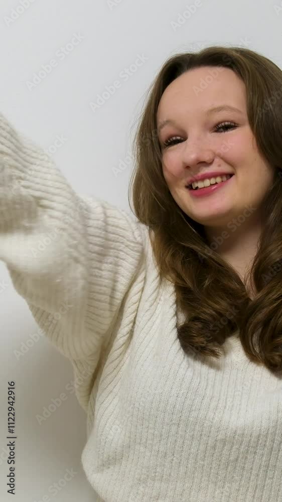 girl poses for photo shoot adjusts sweater leans against wall puts hair ...