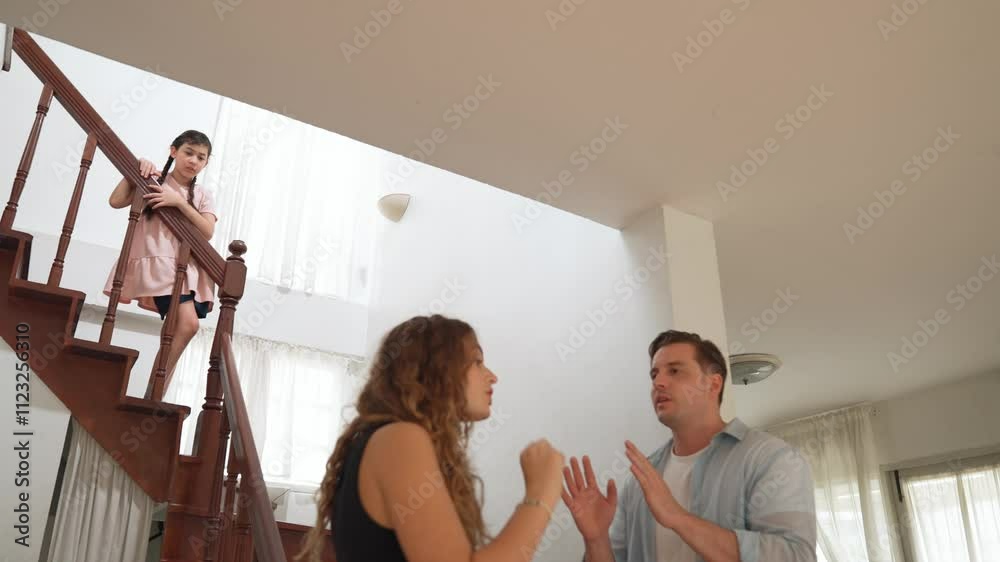 Stressed and unhappy young girl watch her parent arguing from the stair ...
