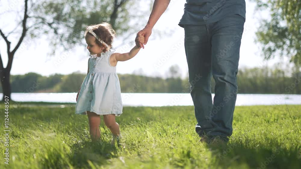 Father and child walking outdoors. Child holding father hand in park ...