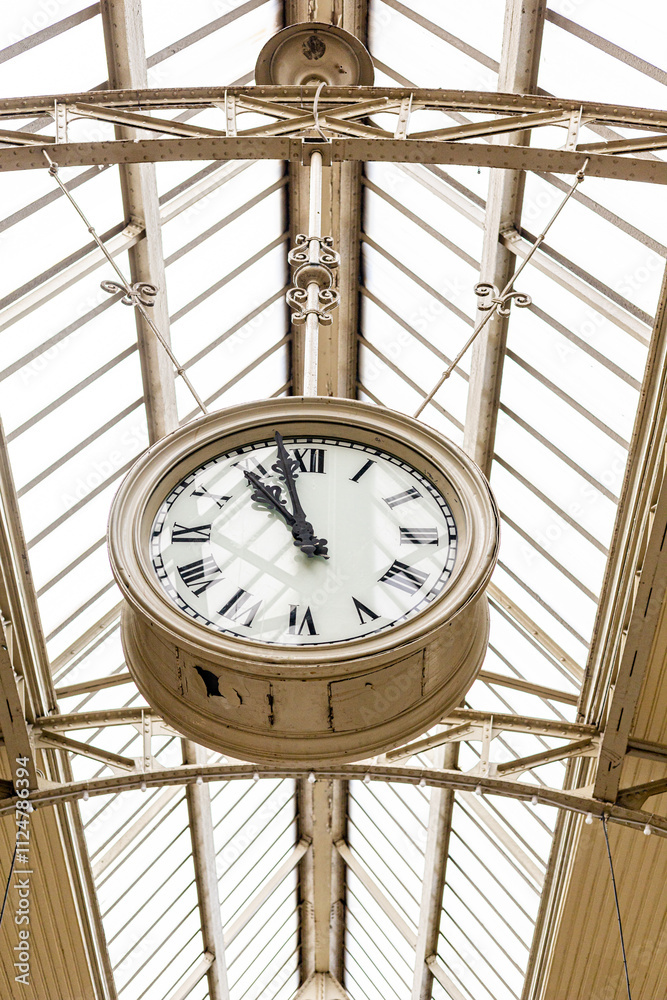 a large clock suspended from the ceiling of a majestic building with a ...