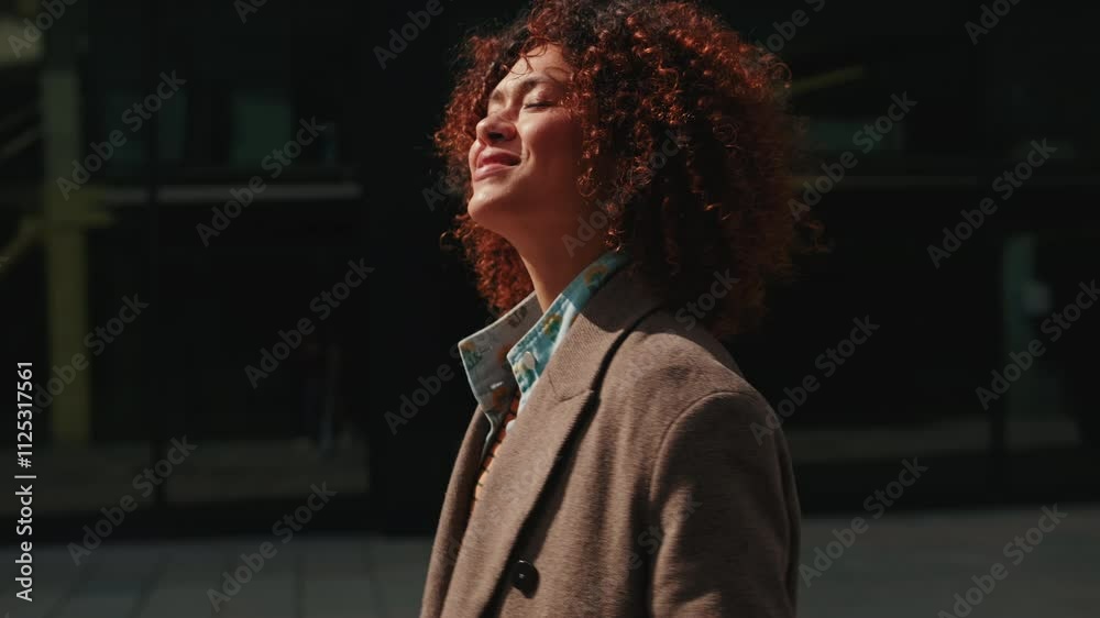 A happy businesswoman walks through the city during her daily commute ...
