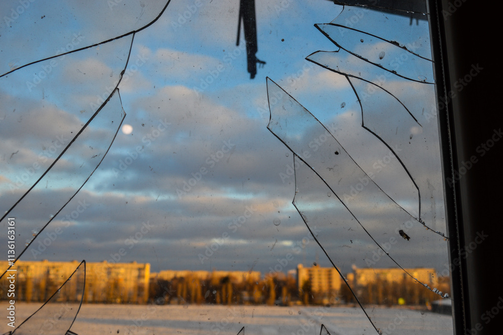 cracked windowpane with sharp broken glass clear blue sky clouds ...