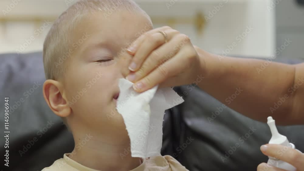 Mother using salt water nasal spray to rinse her child's nose ...