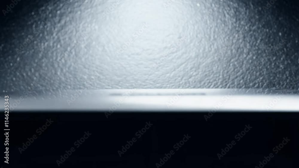 Zoom-out video revealing a metallic surface with dramatic shadows ...