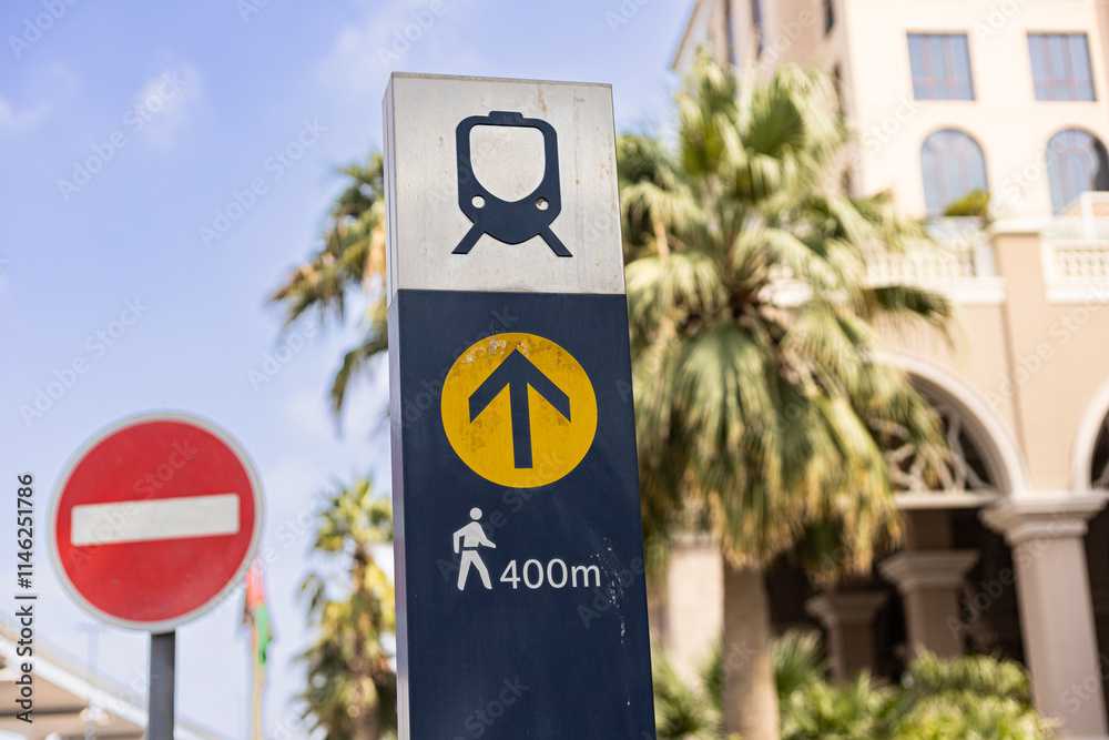 Signpost of Dubai Metro with a blue background and white lettering. The ...