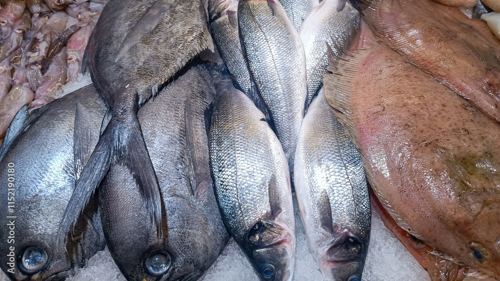 Poster Diferentes especies de pescado en el mostrador de una pescadería ...