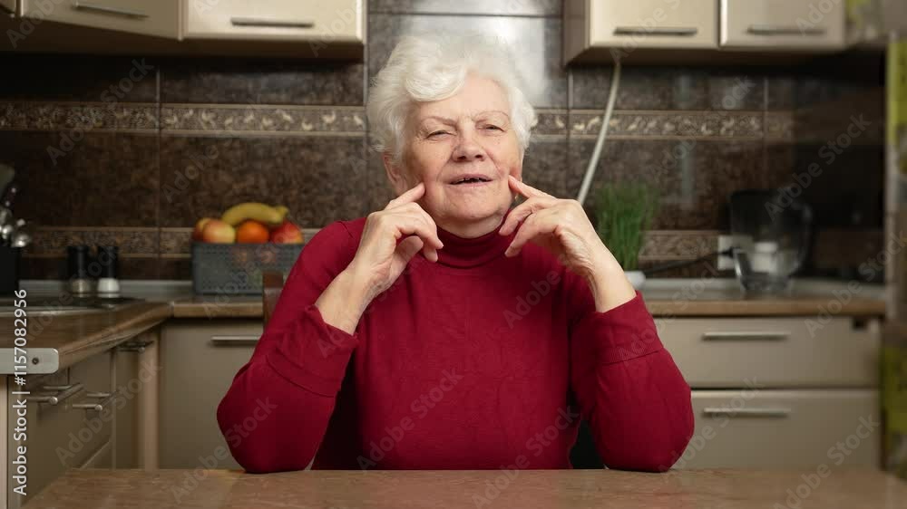 Elderly woman is being silly. Old female fills cheeks with air and ...