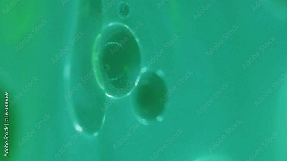 Foam emulsion. Fizzy liquid. Defocused green color transparent round ...
