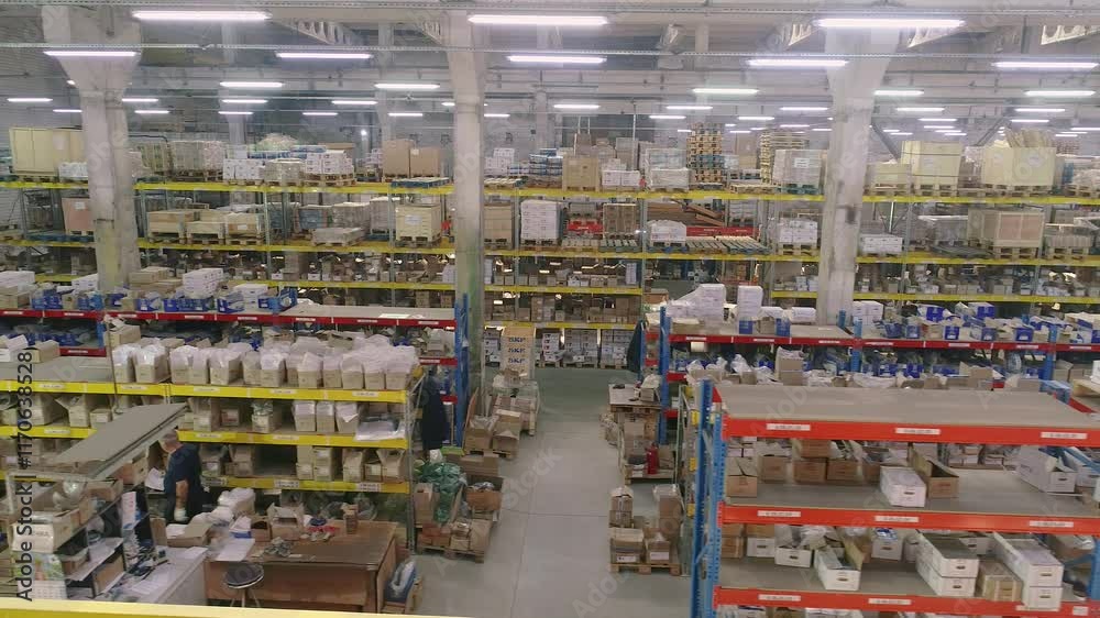 Rows of racks in a large multi-level warehouse. Spanning along racks ...