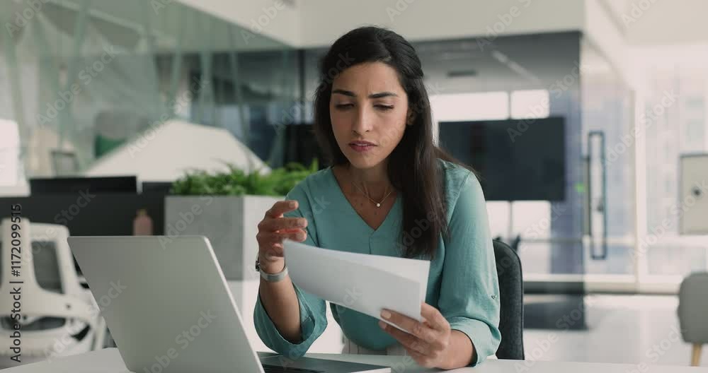 Latina woman employee sit at desk in office, hold papers, read negative ...