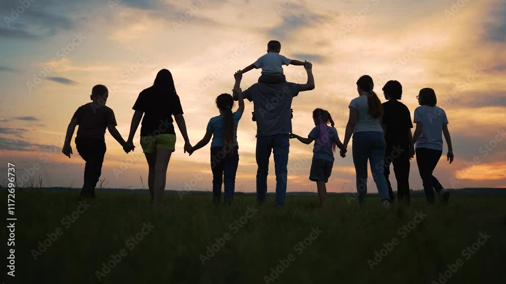 Unity group walking together at sunset. Silhouette of people holding ...
