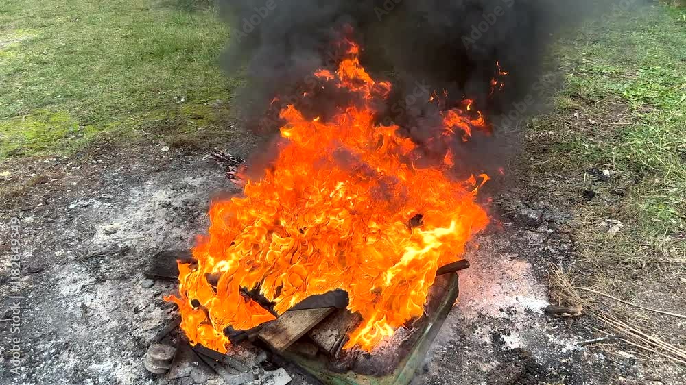 Sofa in fire smoke. Old sofa is burned in a bonfire, fire burning ...