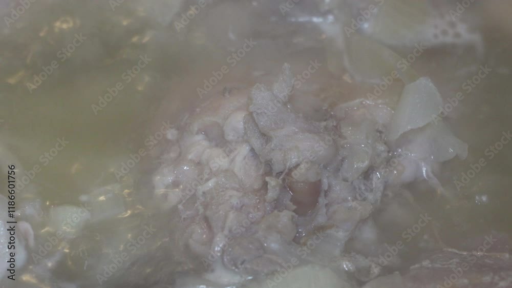 boiling broth from a bone, boiling soup with meat close-up, a bone is ...