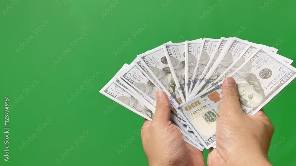 Green screen footage of a stack of dollar bills in the hands of the ...