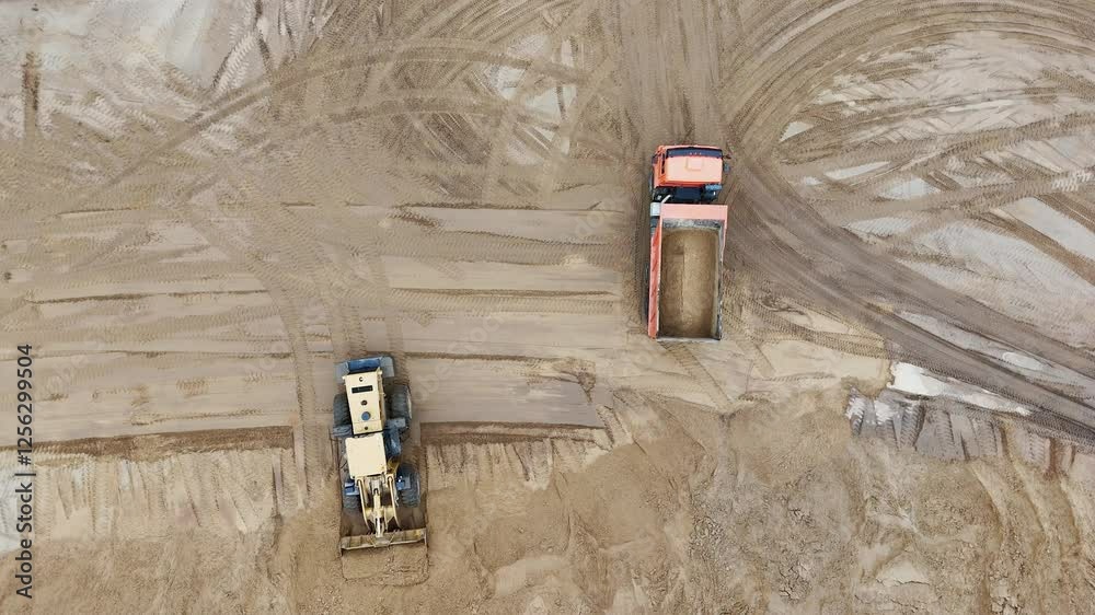 Loading sand with a tractor into a big truck. In a sand pit. Getting ...