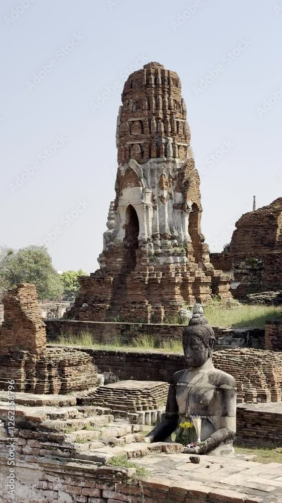 Vertical panorama of a Buddha statue and ancient stupa at Ayutthaya ...