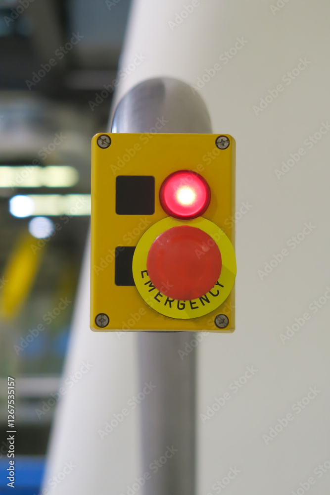 Poster close up of an emergency stop push button with a red light on ...