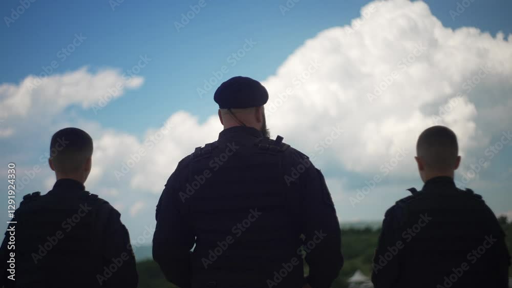 Back view of a tactical officer in a beret standing with his two sons ...