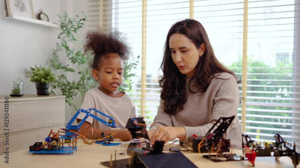 Loving mother and daughter team up for a fun robotics project at home ...