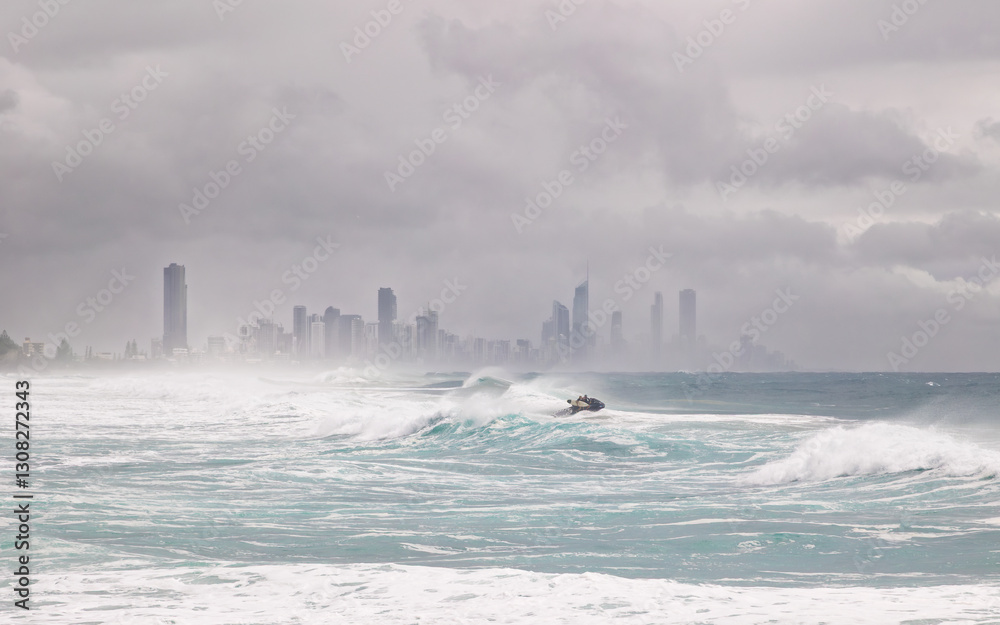 Poster Heavy surf with a personal water craft taking a surfer out to ...