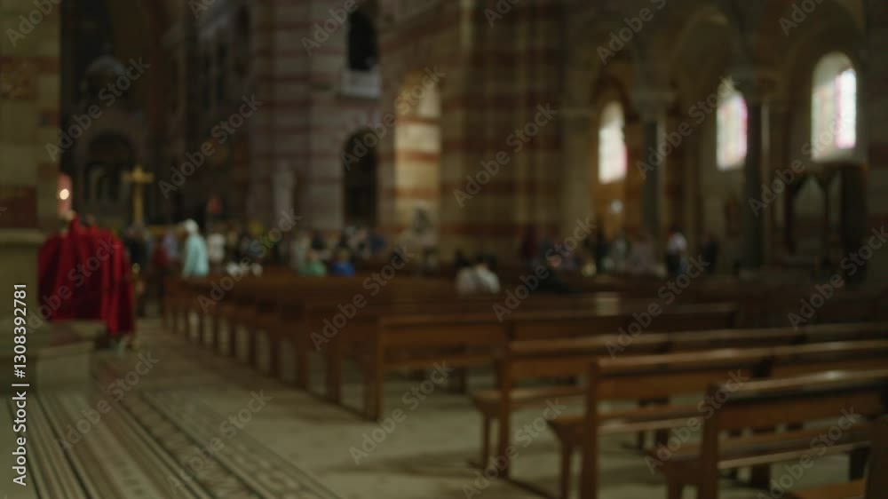Defocused interior of a church with blurred people in pews highlights ...