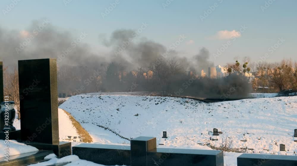Crematorium smoke rising over a snowy cemetery, symbolizing death ...