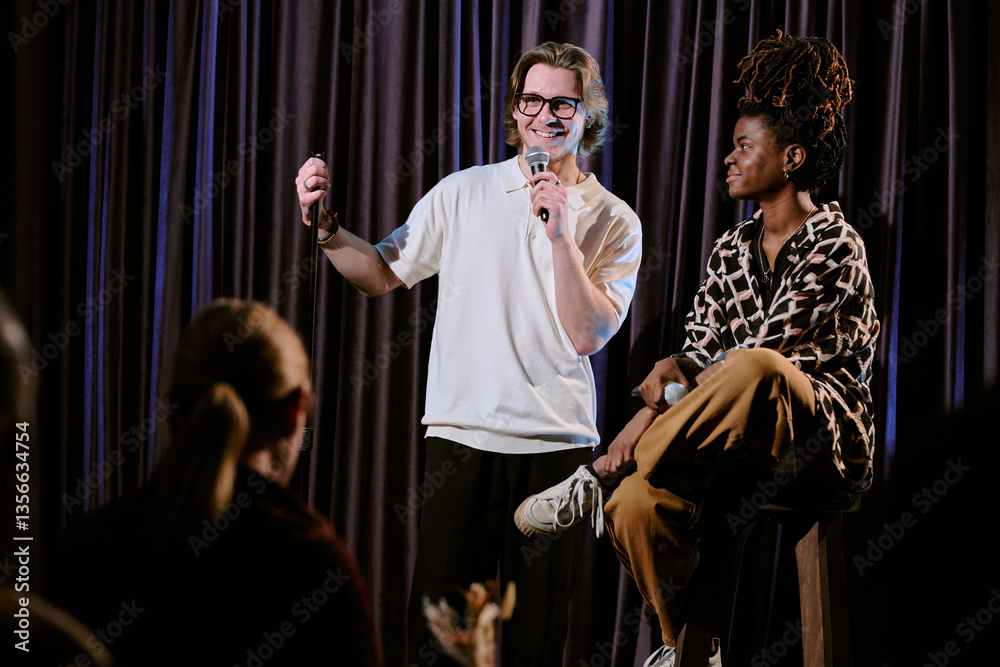 Poster Comedian performing stand-up comedy routine on stage holding ...