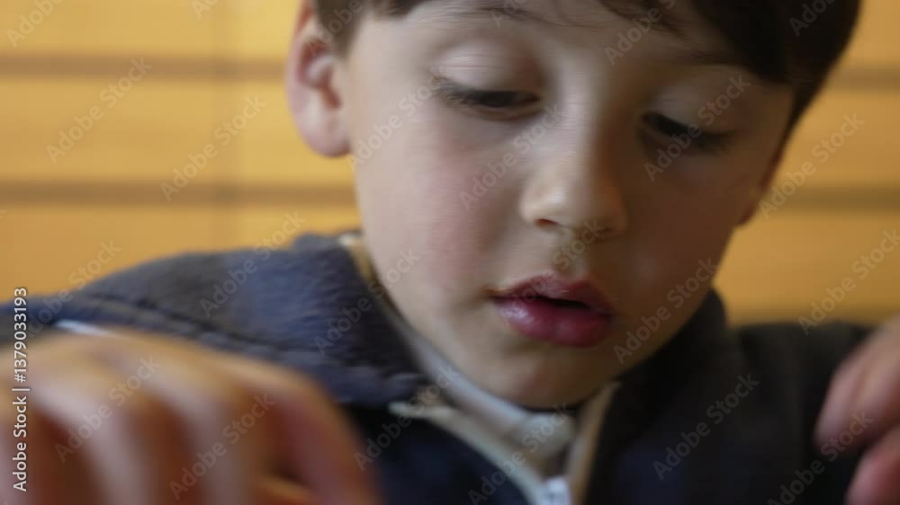 Boy quickly pulls away a hot fry from his mouth, expressing surprise ...
