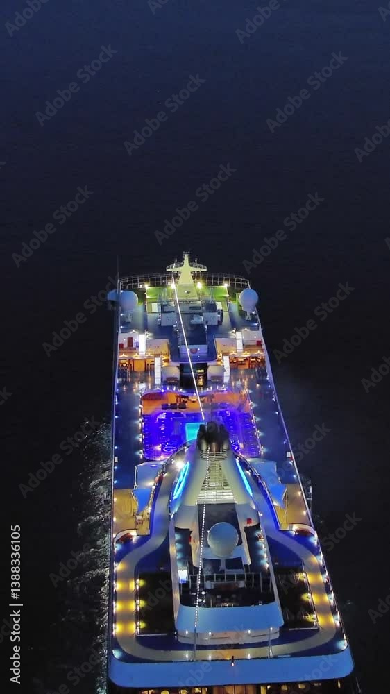 Aerial view of illuminated large cruise ship in the sea at night ...