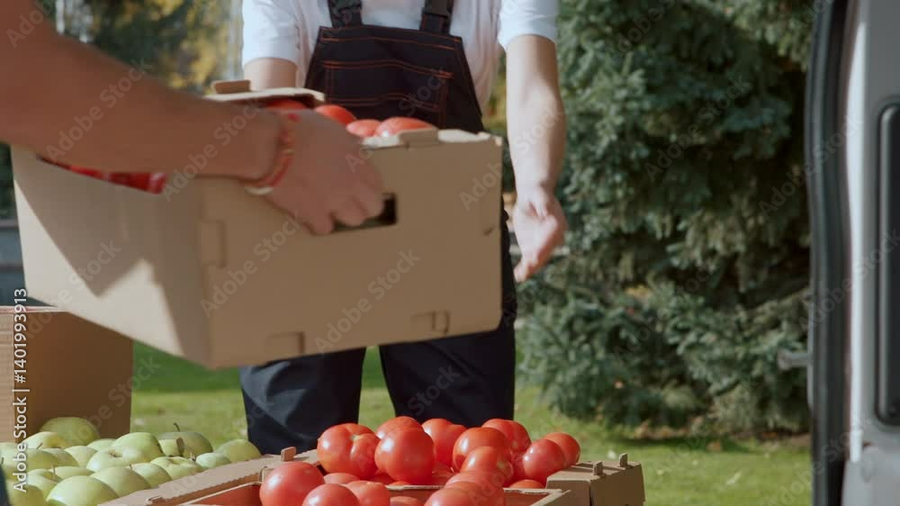 Man and woman in uniform unloading boxes with vegetables and fruits ...