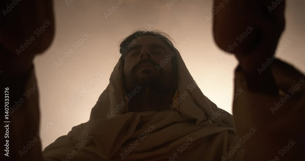 Jesus Christ in white hooded robe holding bread as he stands in glowing ...