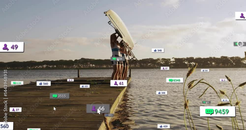 Team of rowers carrying racing shell on lakeside dock, showing ...