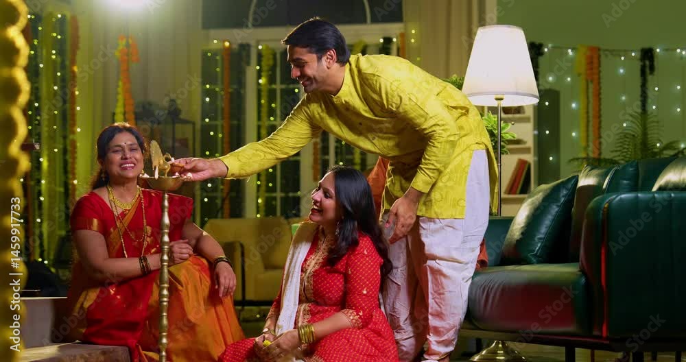 Lighting samai diya indoors during Diwali, Indian family of four ...