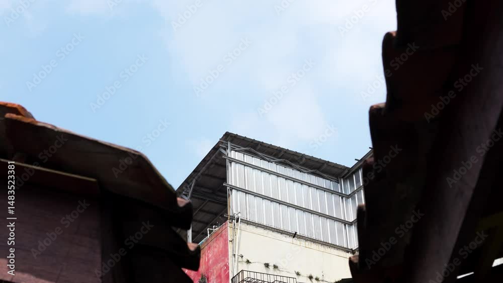 reveal shot high rise building middle of slum between roof tile sunny ...