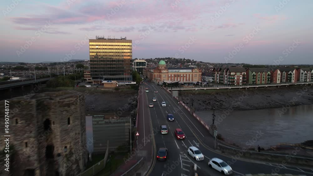 Cars driving on bridge over river, building on waterfront reflecting ...
