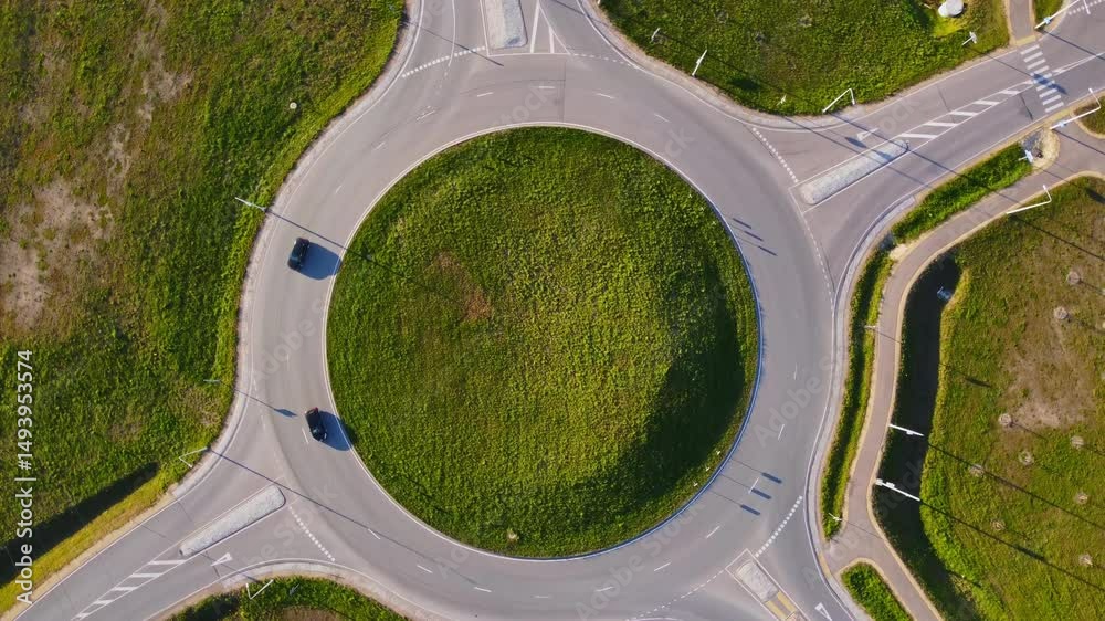 Spinning top down drone shot captures a circular traffic roundabout ...