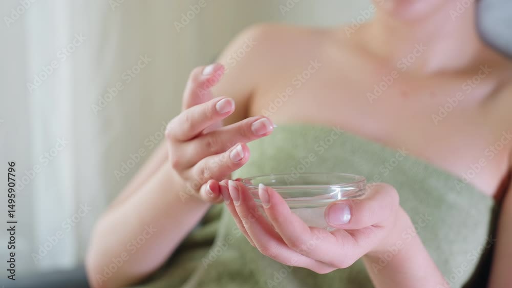 Hand view of girl dipping finger deep into cream and applying it ...